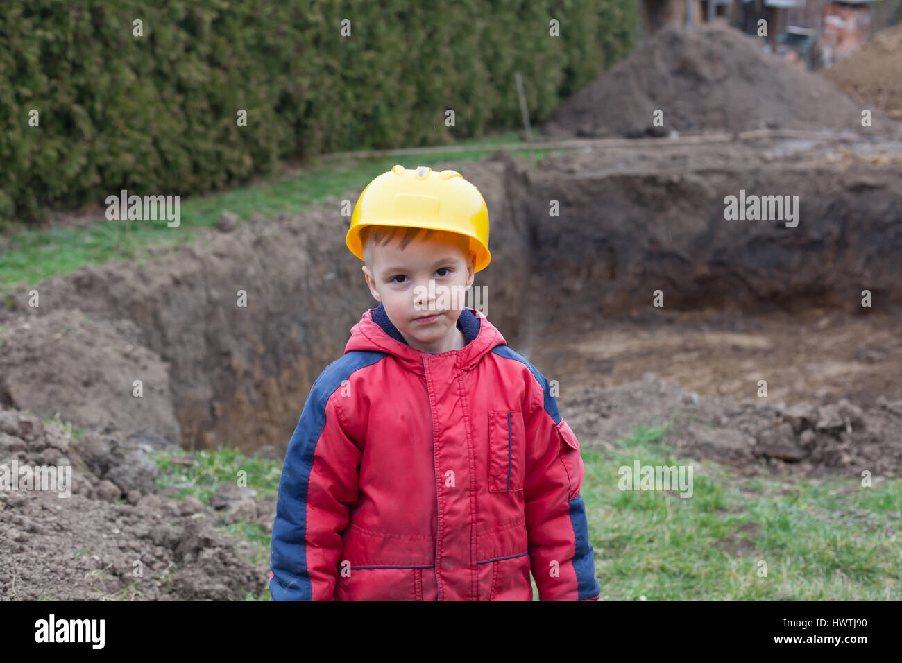 Little boy with a spade helps parents during the construction of the ...