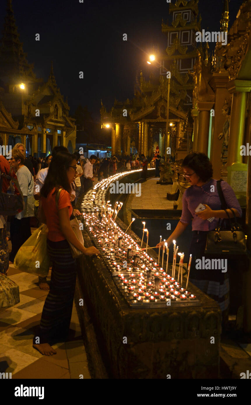 Tourists light candles in the evening at Shwedagon Pagoda, Yangon ...