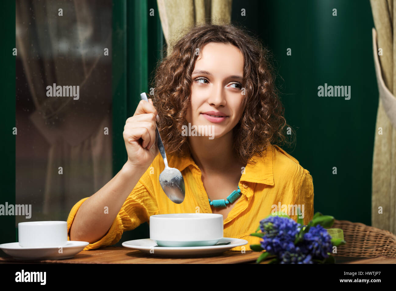 Happy young woman eating a soup at restaurant Stock Photo - Alamy