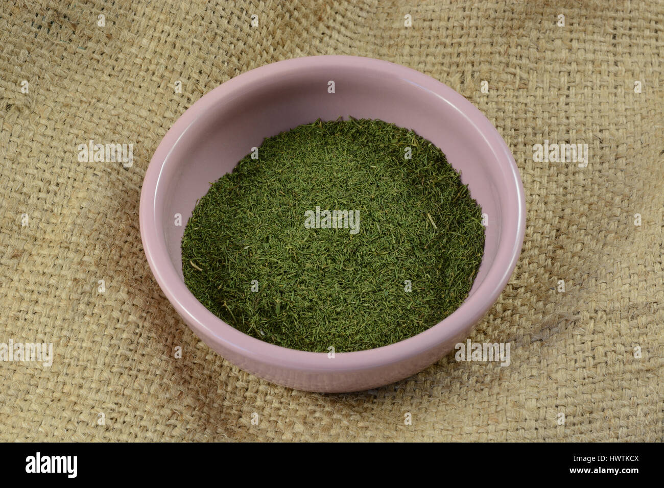 Dill weed spice in pink condiment dish on burlap Stock Photo - Alamy