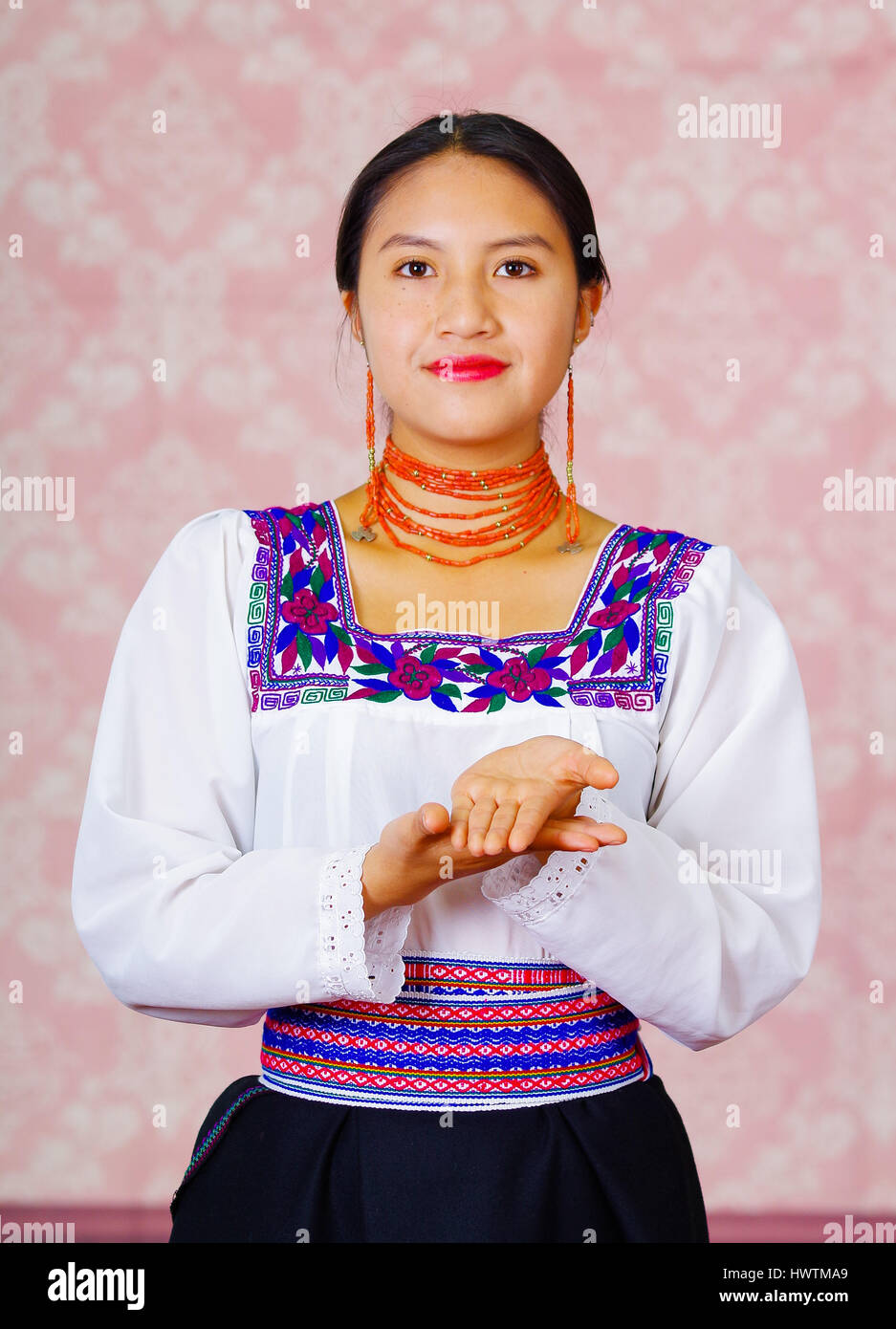 young-woman-wearing-traditional-andean-dress-facing-camera-doing-sign