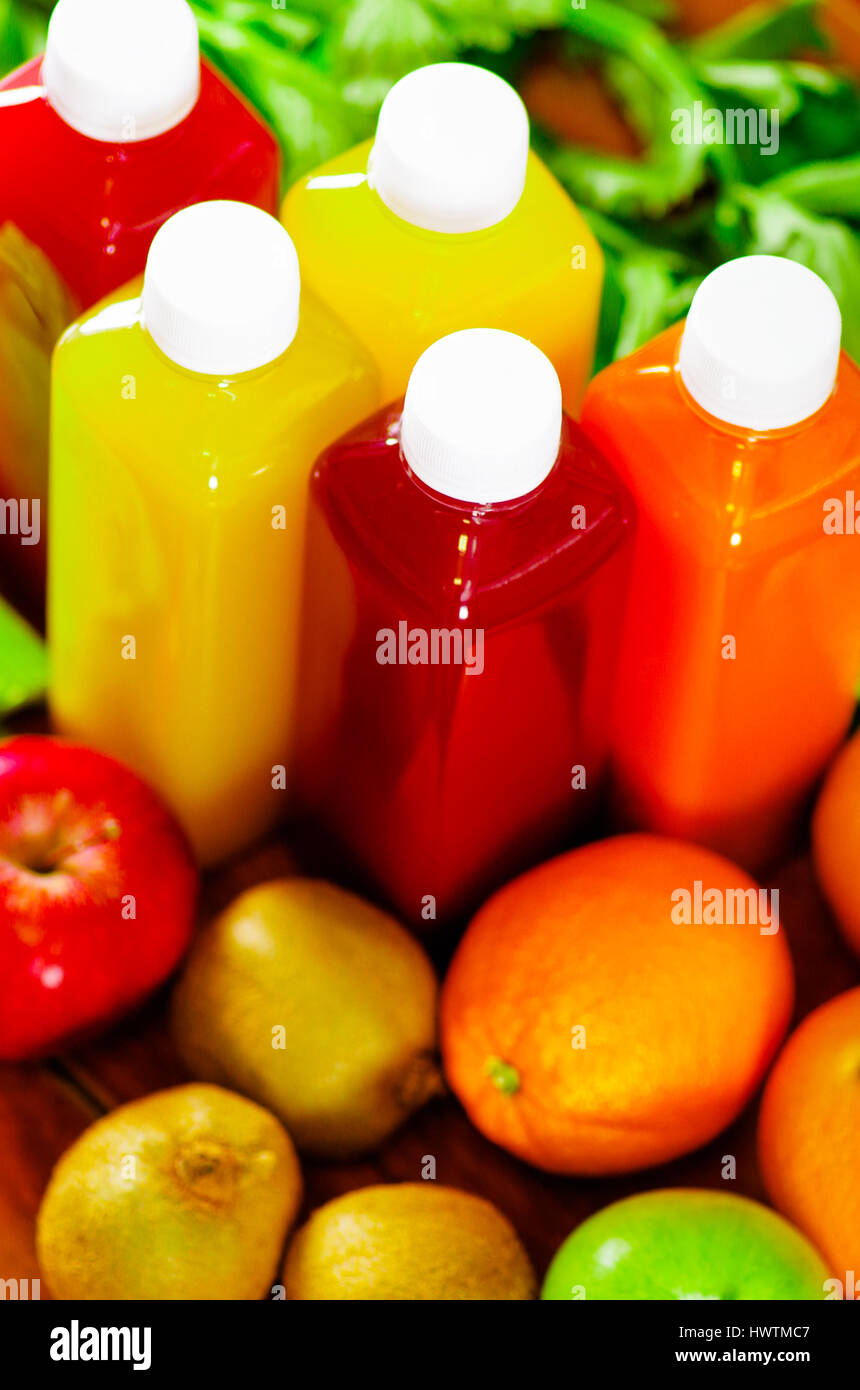 Bottles of delicious organic juice sorrounded by fruits and veggies ...