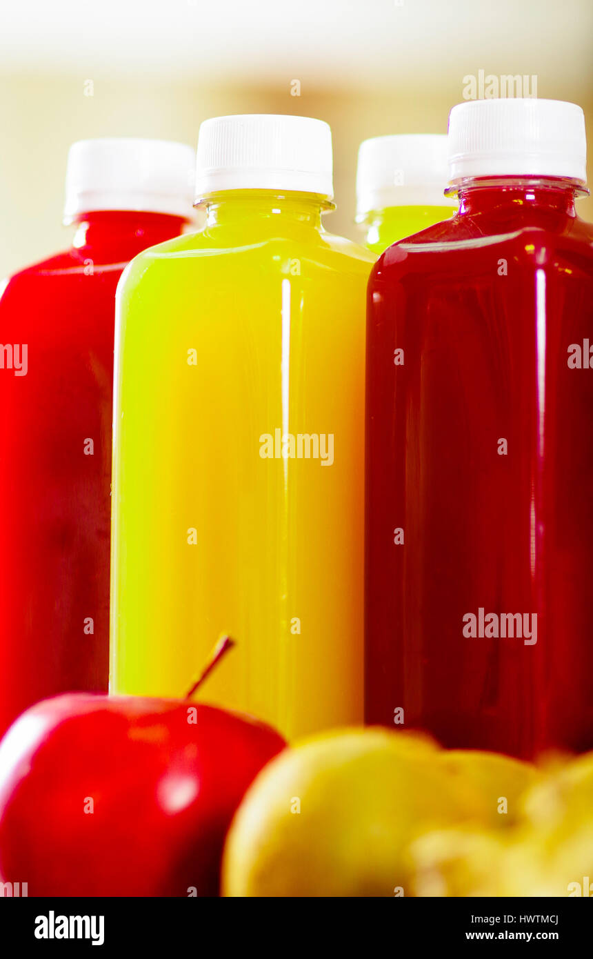 Bottles of delicious organic juice sorrounded by fruits and veggies ...