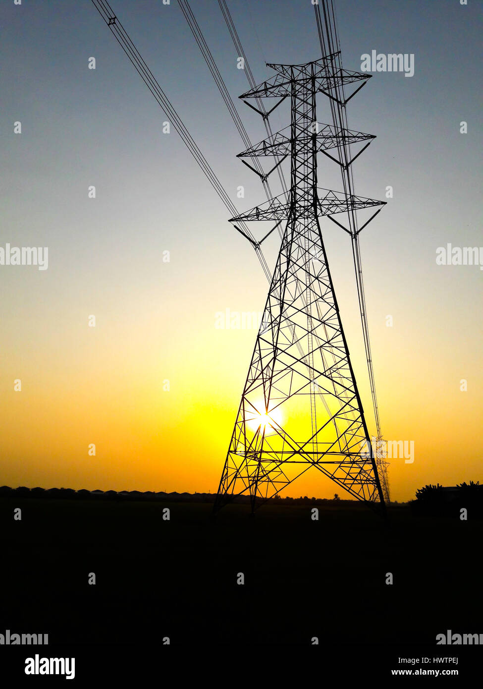Electric high voltage power post at sunset Stock Photo - Alamy
