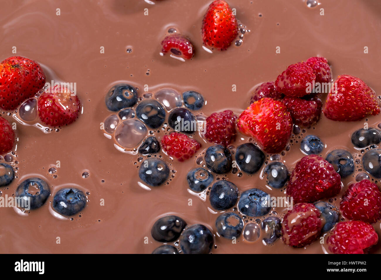 muesli and fresh berries and fruits with chocolate milk background ...