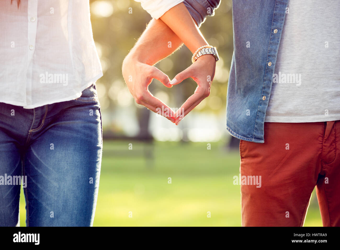 Couple in love making heart with hands Stock Photo - Alamy