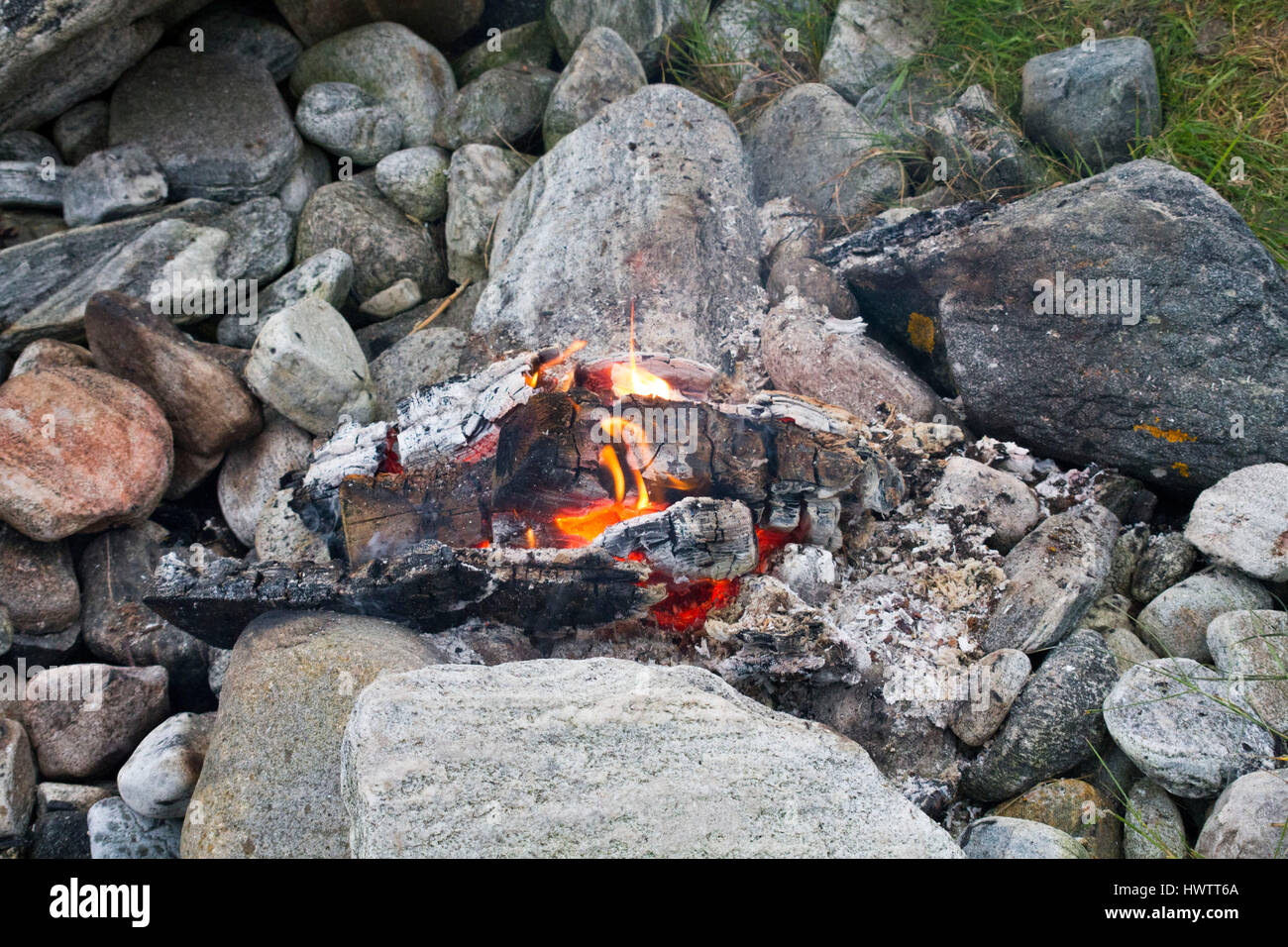 Camp fire on seashore rocks , CAMPER S FIRE Stock Photo - Alamy