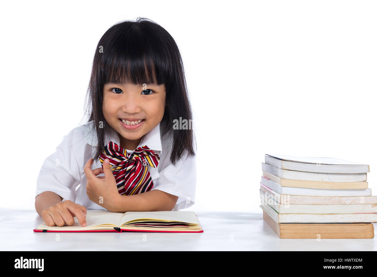 Happy Asian Chinese little girl reading book in isolated white ...