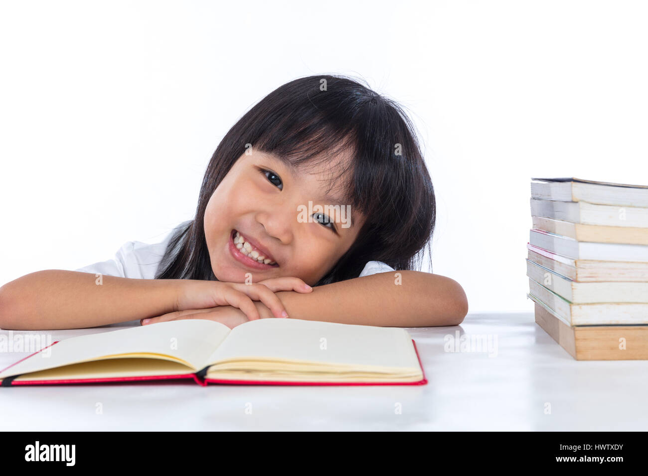 Smiling Asian Chinese little girl reading book in isolated white ...