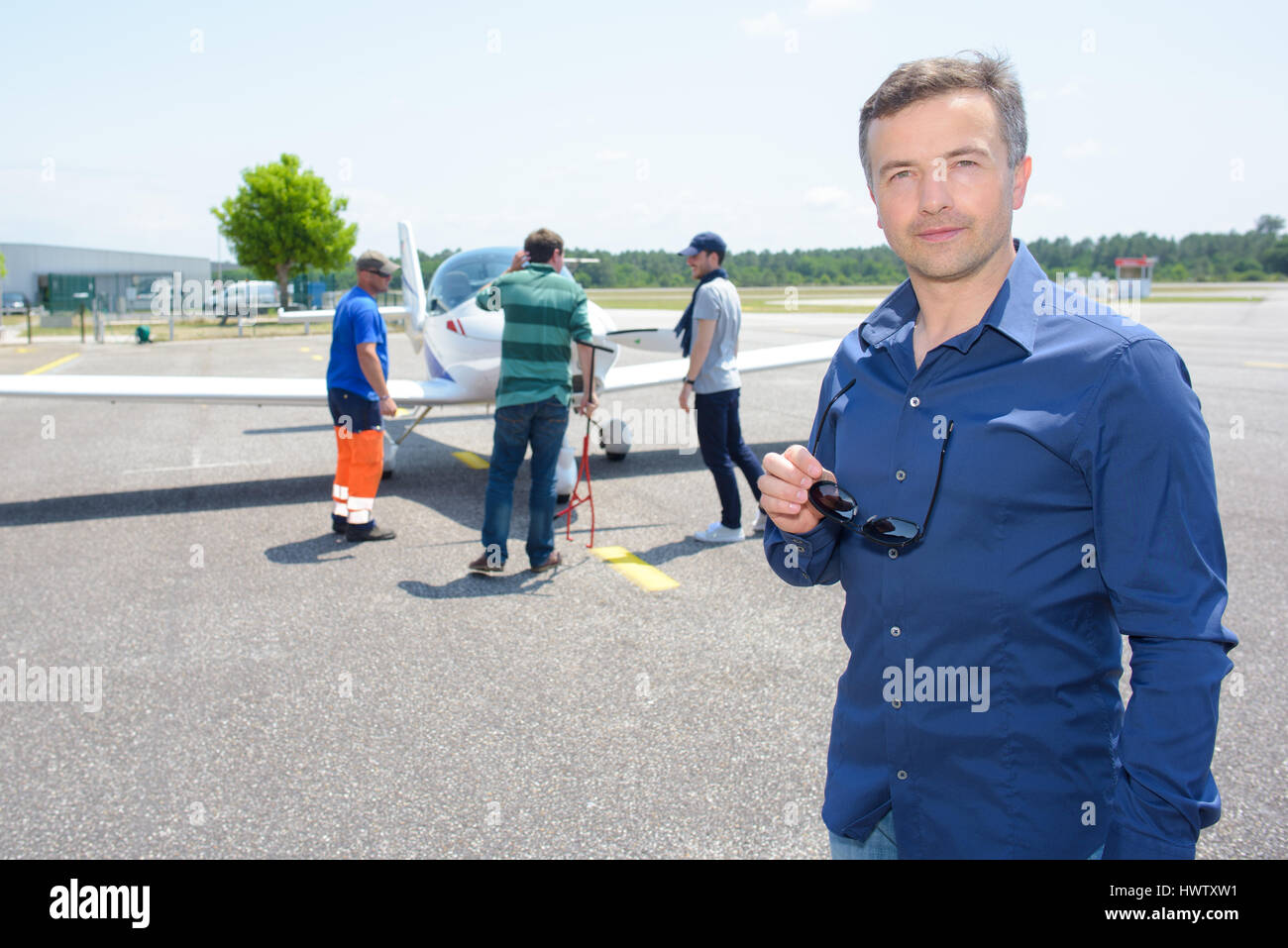 Portrait of man in airport, technicians checking his plane Stock Photo ...