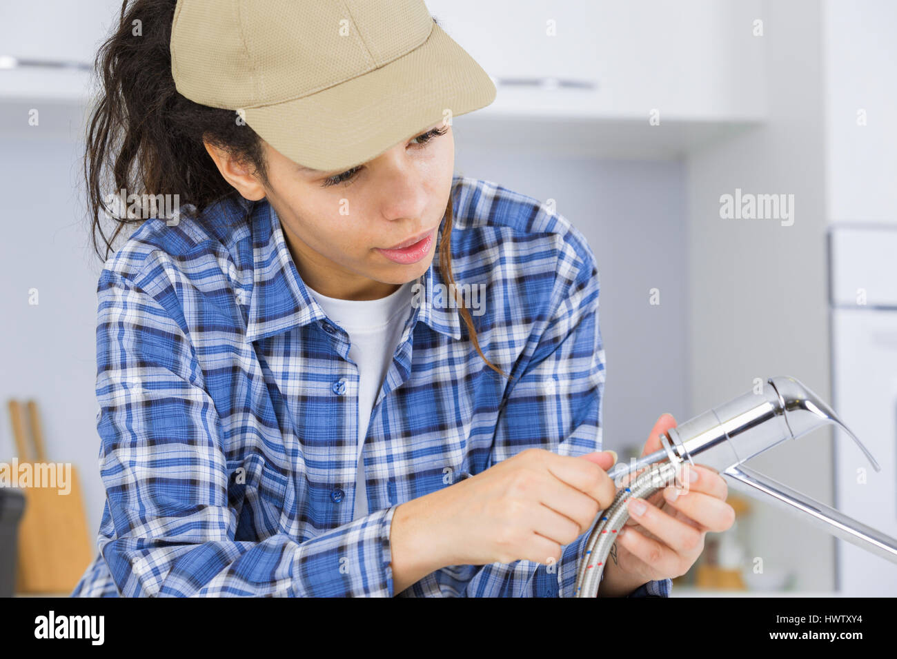 Woman installing new tap Stock Photo - Alamy