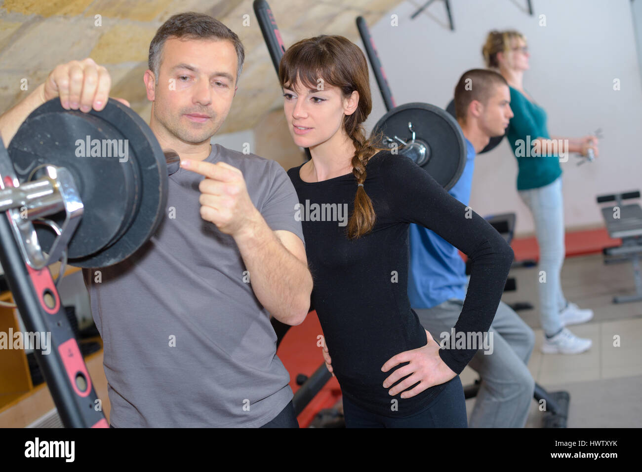 trainer explaining how to use training machine in a gym Stock Photo - Alamy