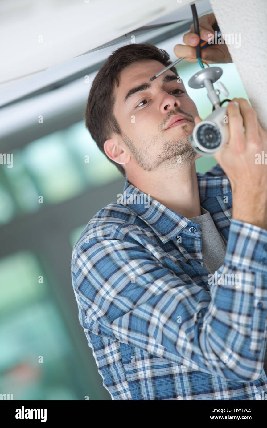 Man fitting surveillance camera Stock Photo - Alamy