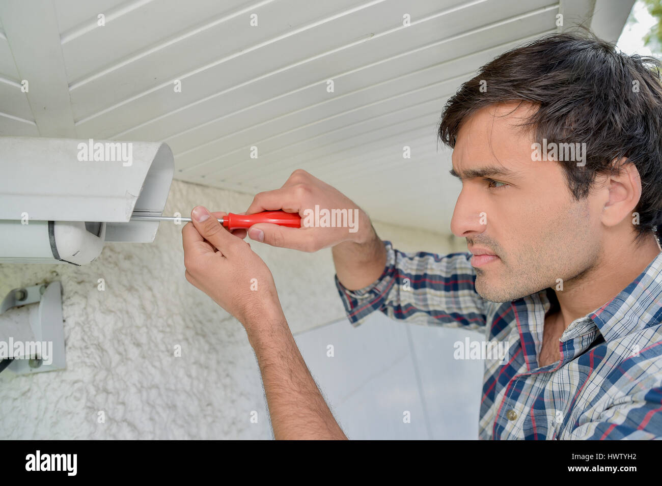 Man repairing a security camera Stock Photo - Alamy