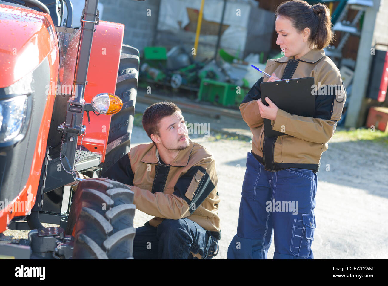 agricultural mechanics checking tractors condition before harvesting ...