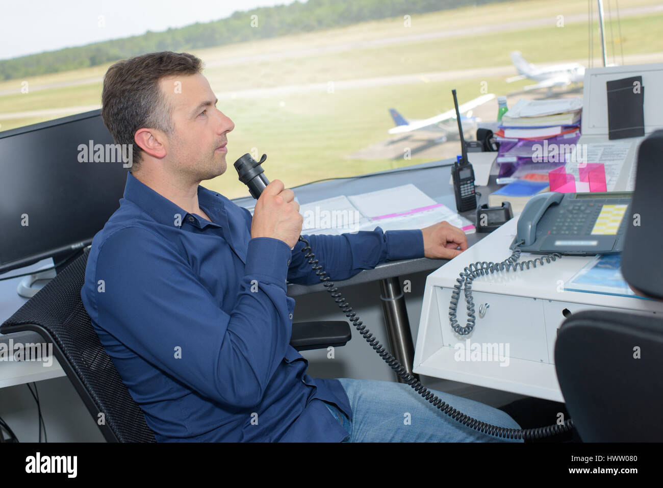 Man communicating from airport control tower Stock Photo - Alamy