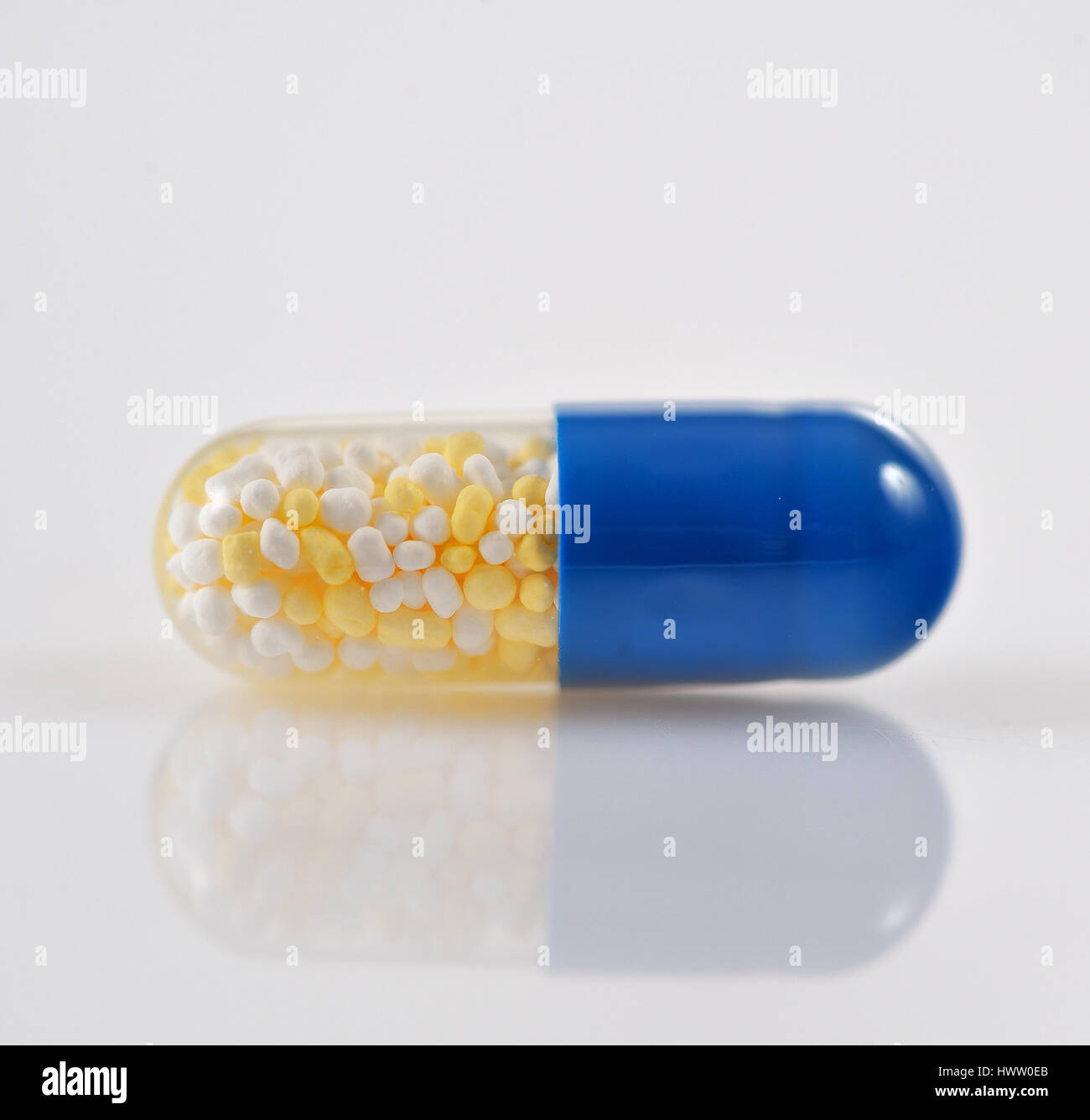 One single pill isolated on white table Stock Photo - Alamy