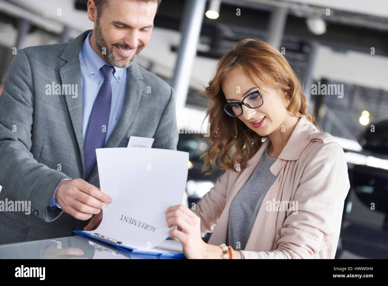 Woman putting signature on the agreement Stock Photo - Alamy