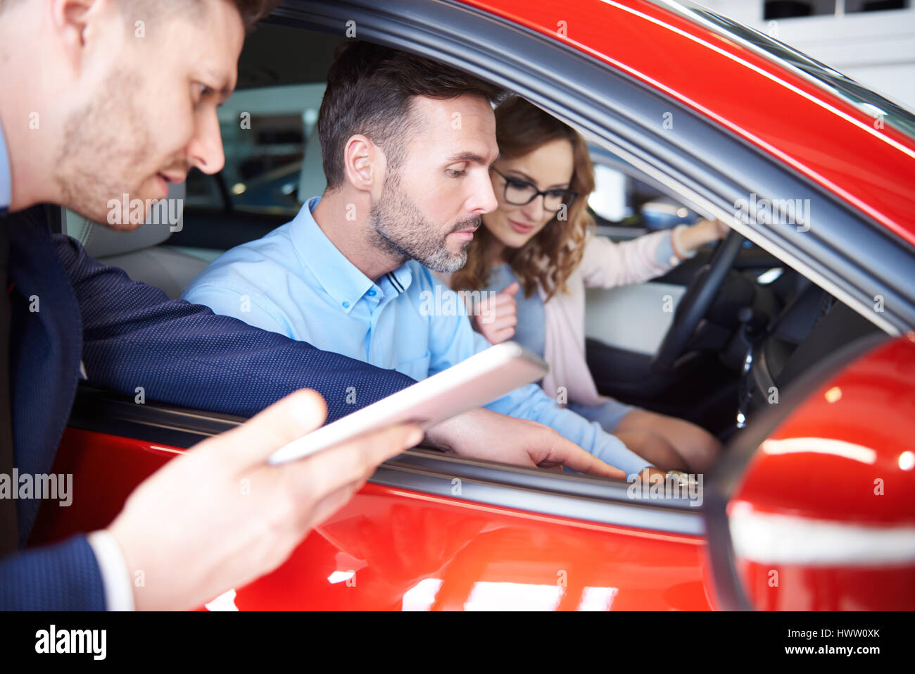Salesman talking to customers in showroom Stock Photo - Alamy