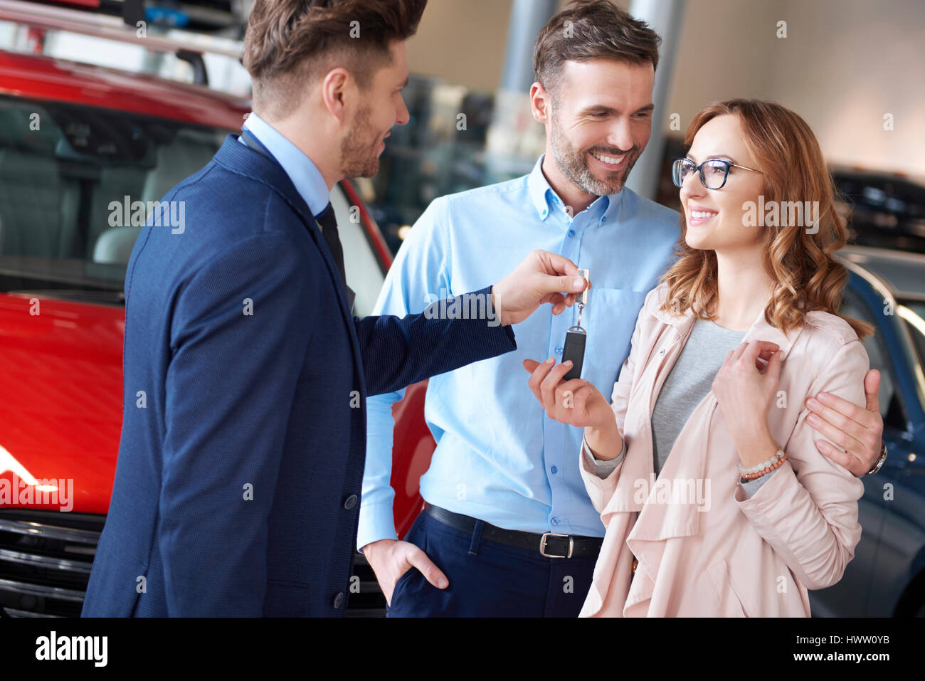 Happy couple getting keys from salesman Stock Photo - Alamy