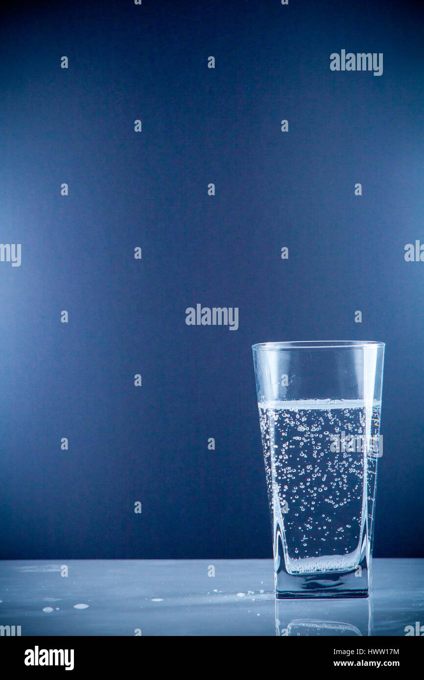 Pure mineral water pouring from a bottle into a glass. bottle of clear drinking cold mineral ...