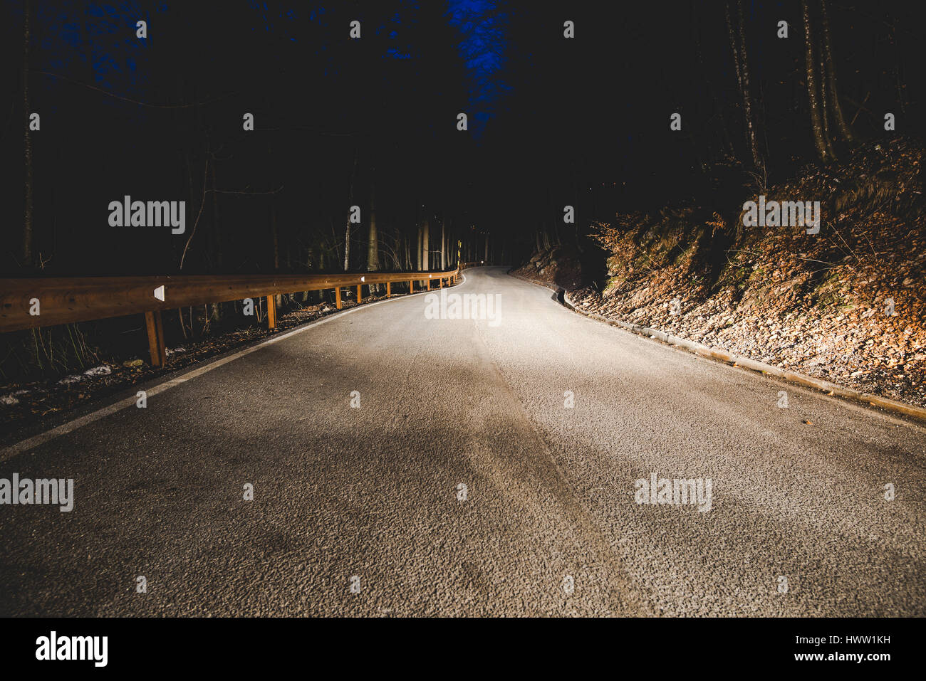 the headlights of a car on mountain road in the night - concept driving ...