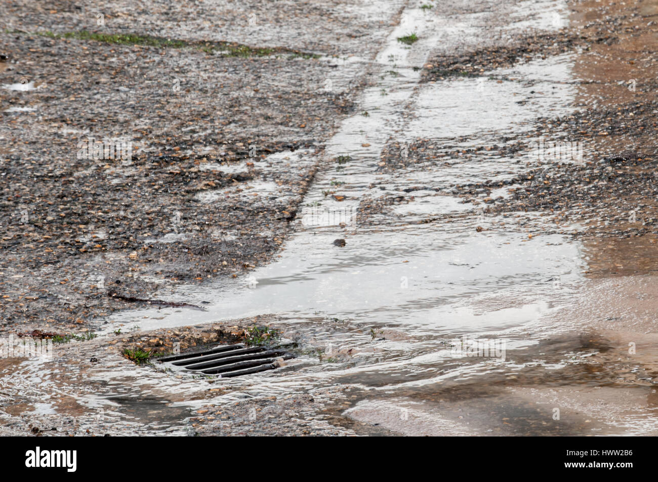 water damage to road from burst leaking water pipe Stock Photo - Alamy