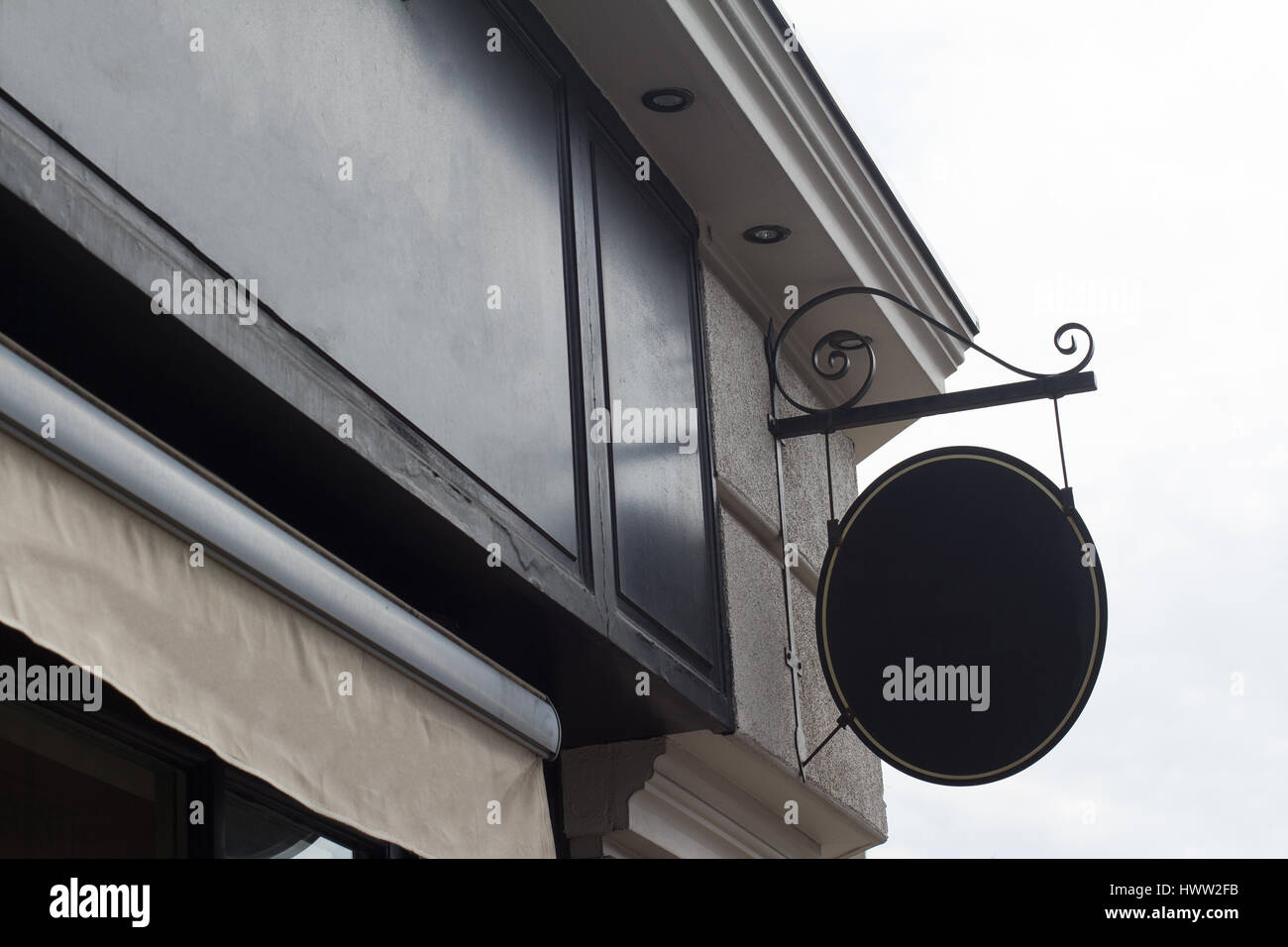 Horizontal front view of black empty round signage on a building with ...