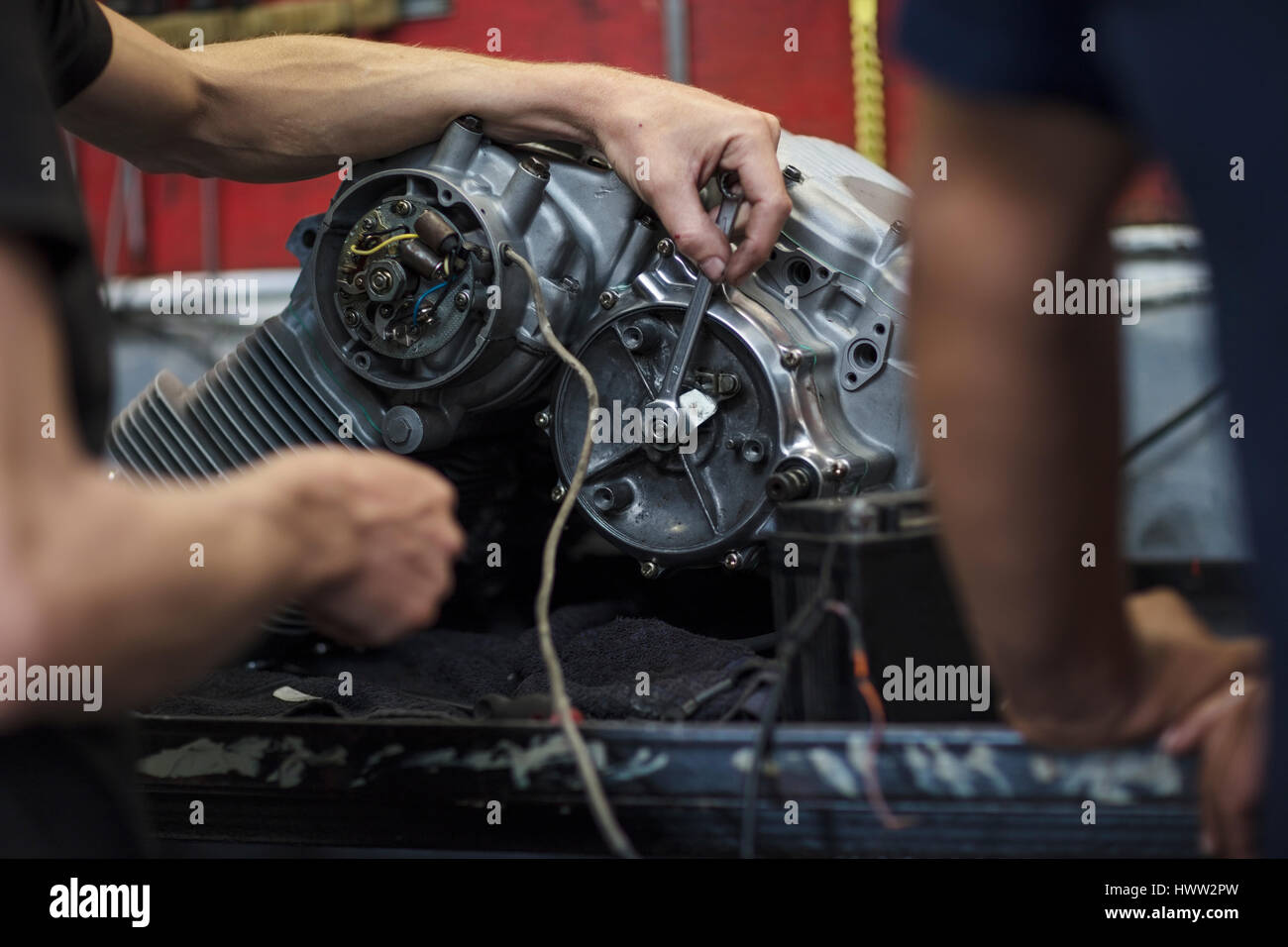 Two mechanics working on motorcycle engine in workshop Stock Photo - Alamy