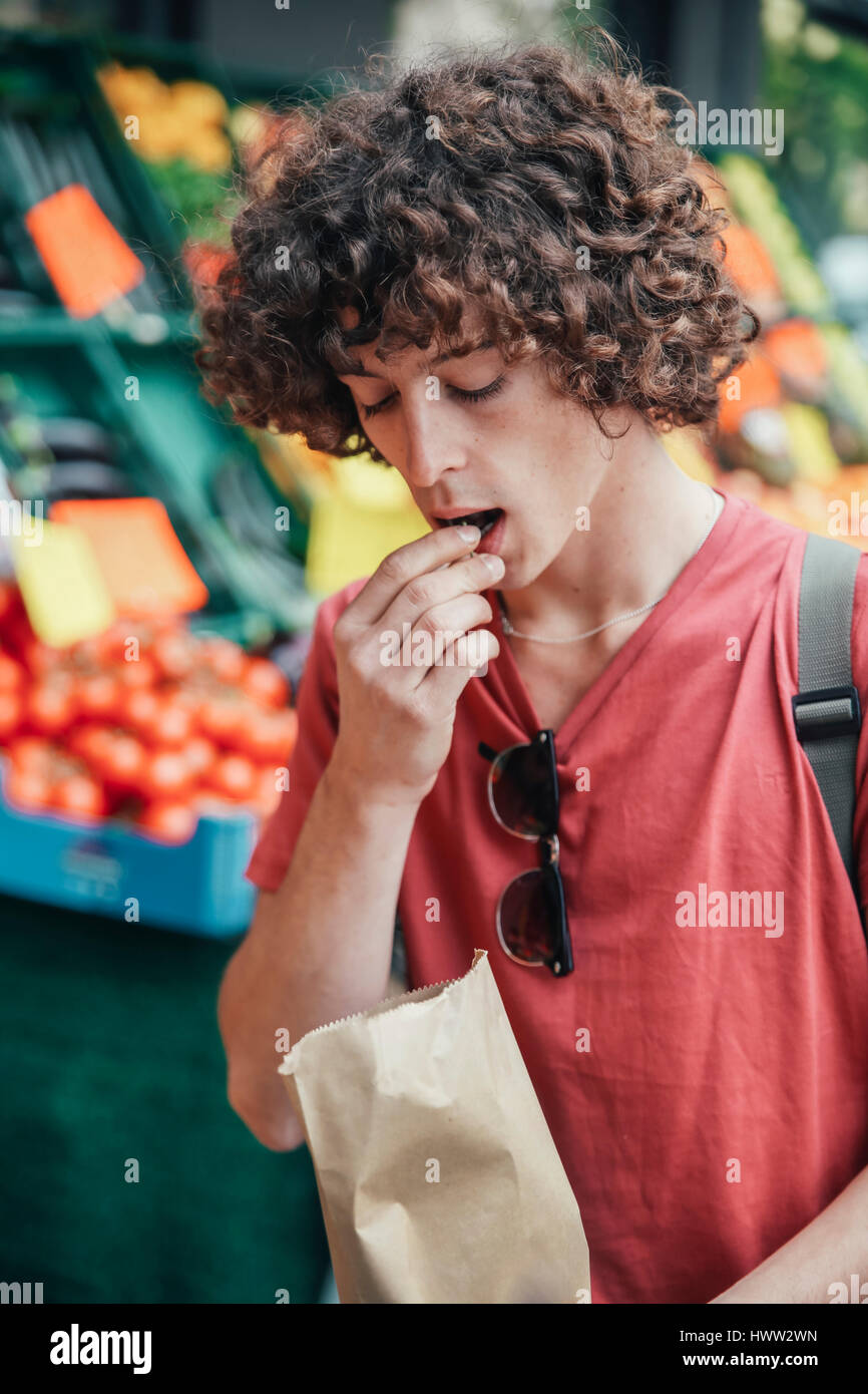 Young man eating cherries in hi-res stock photography and images - Alamy
