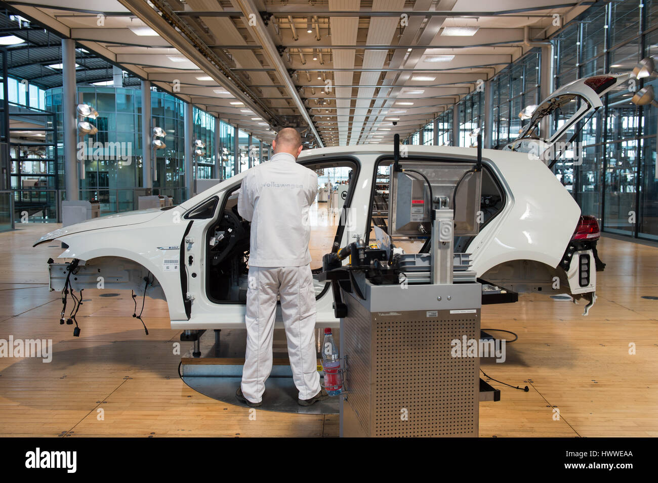 Volkswagen employees work on an E-Golf at the Transparent Factory ...