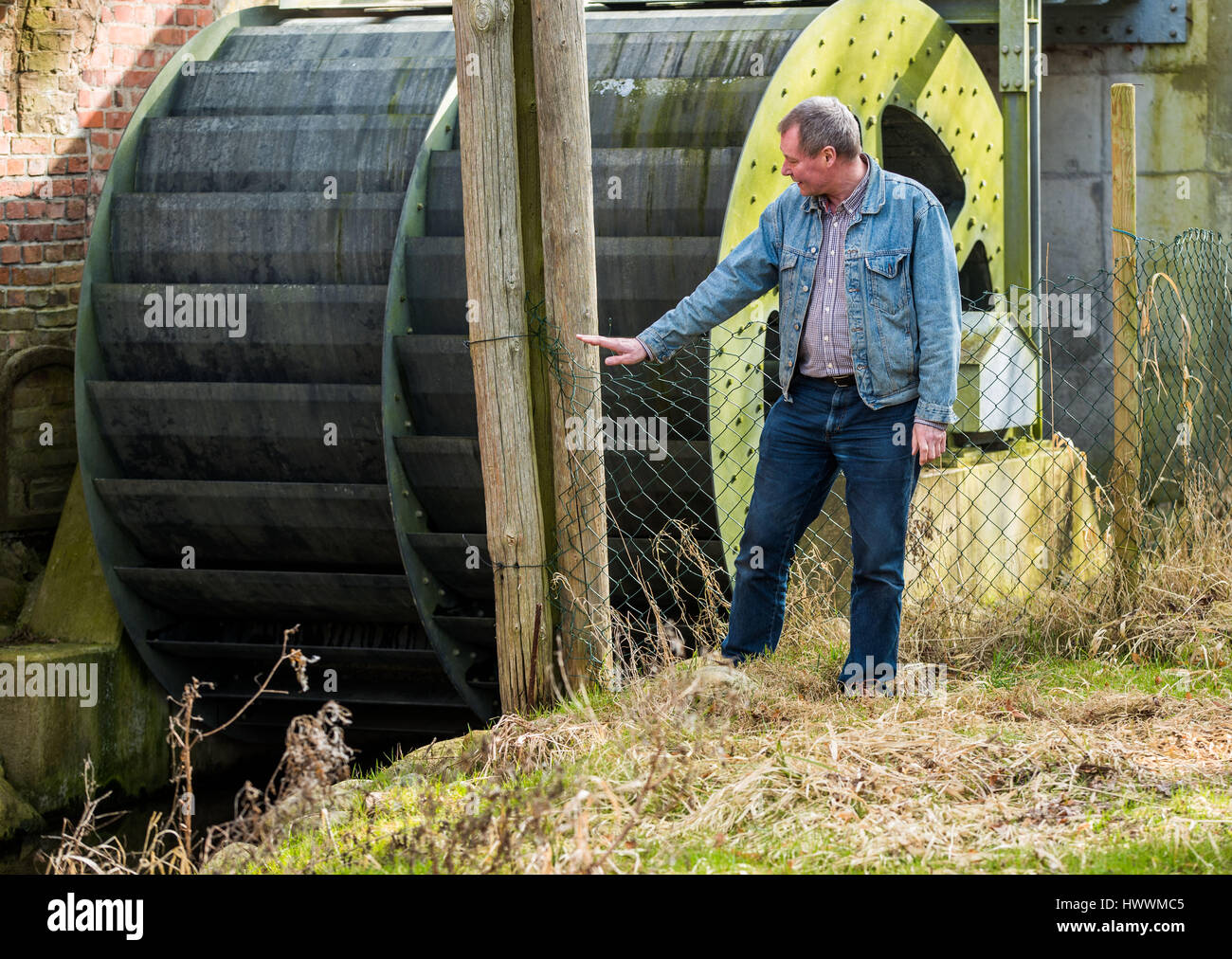 Mill owner Jan Bauditz stands next to the water wheel of his mill in ...
