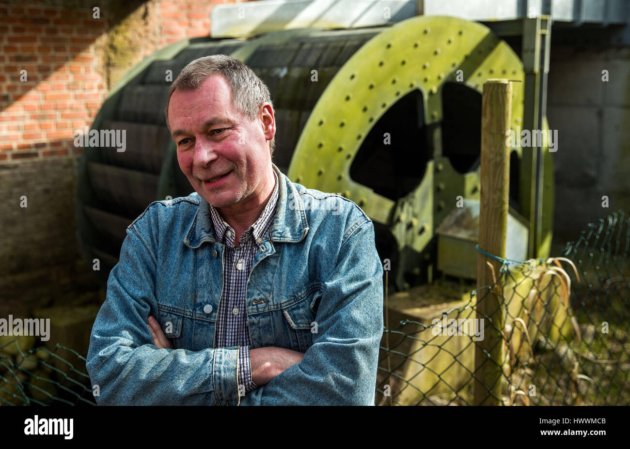 Mill owner Jan Bauditz stands next to the water wheel of his mill in ...