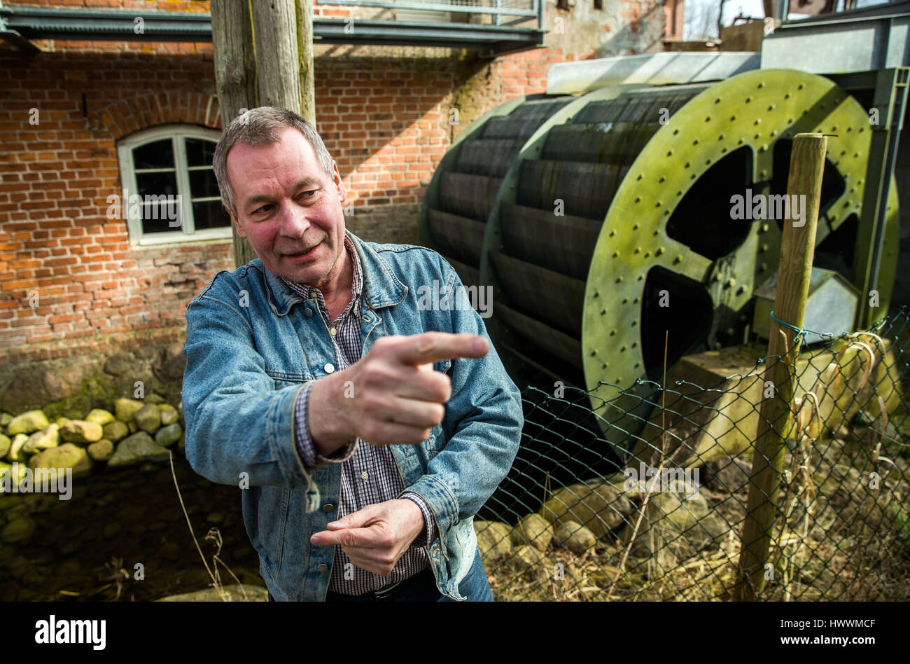 Mill owner Jan Bauditz stands next to the water wheel of his mill in ...