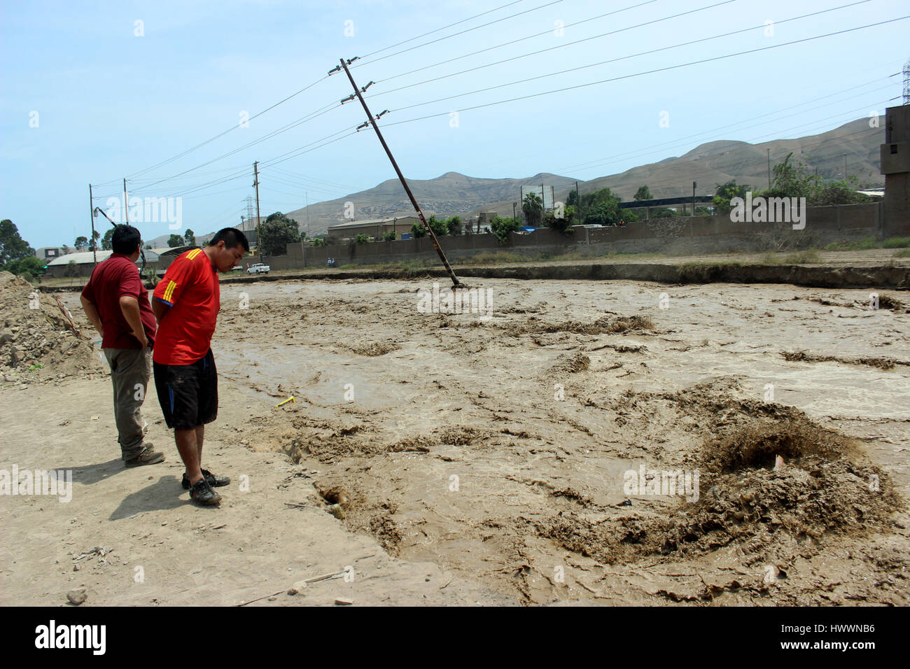 Two men look at the high water of the Chillon river in Lima, Peru, 17 ...
