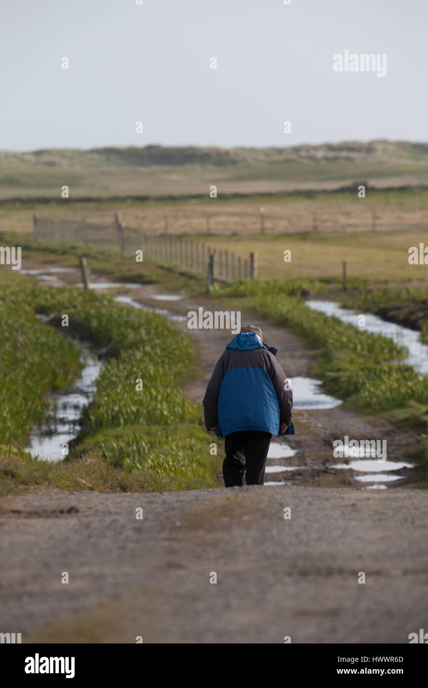 Crofter walking down croft track/ road , to his crofting land ...