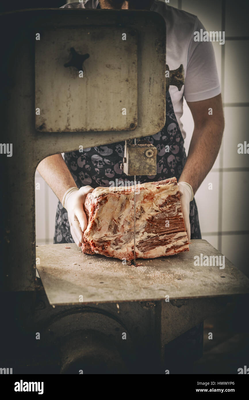 Butcher is cutting meat with bandsaw in butchery Stock Photo - Alamy
