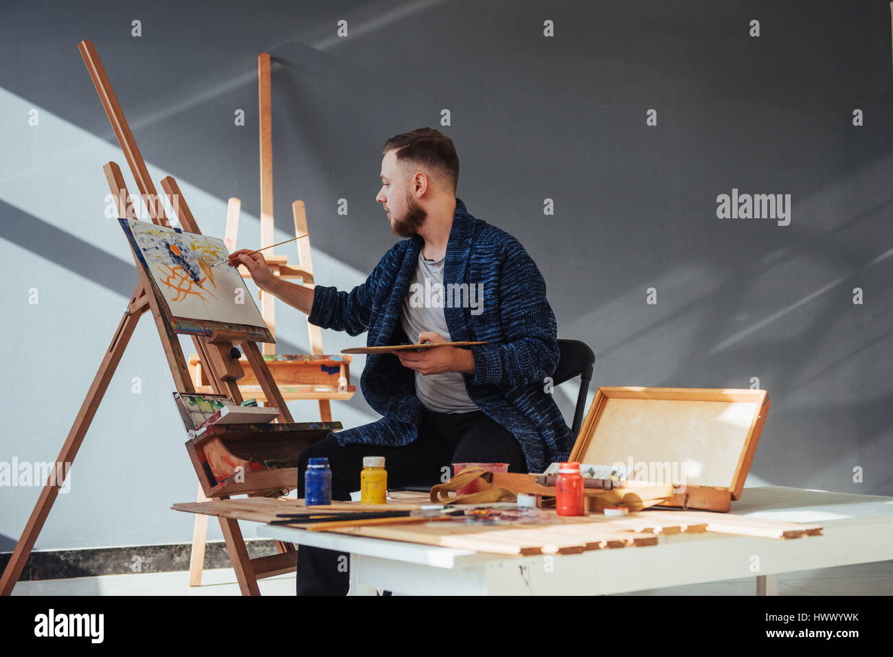 Designed by artist man finishing his masterpiece holds a brush in hand ...