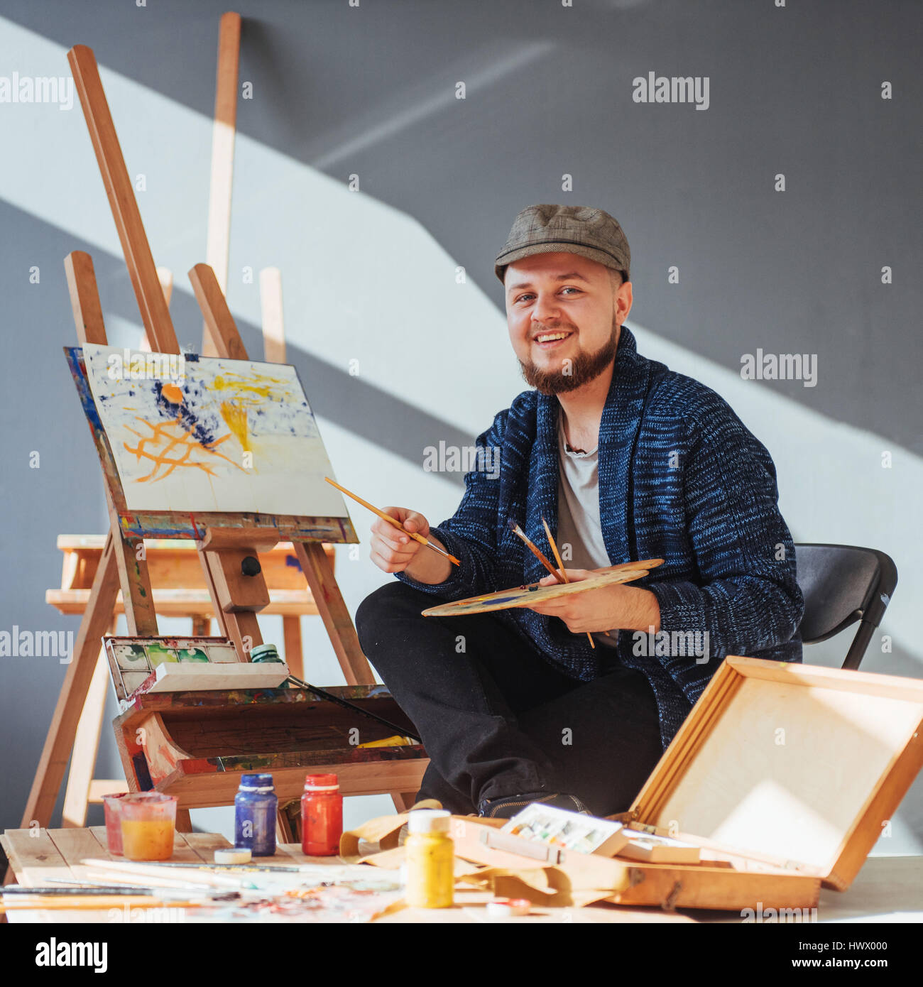 Designed by artist man finishing his masterpiece holds a brush in hand ...