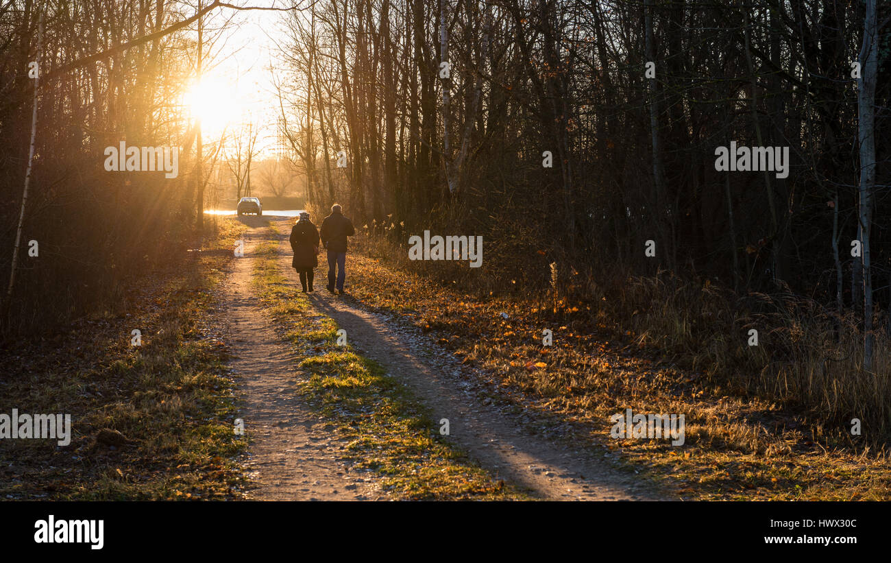 PEOPLE WALKING ON the road in the countryside with trees in surrounding ...