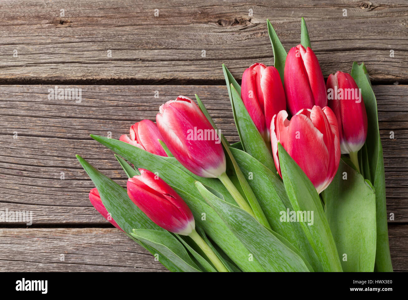 Red tulips bouquet on wooden background. Top view with space for your ...