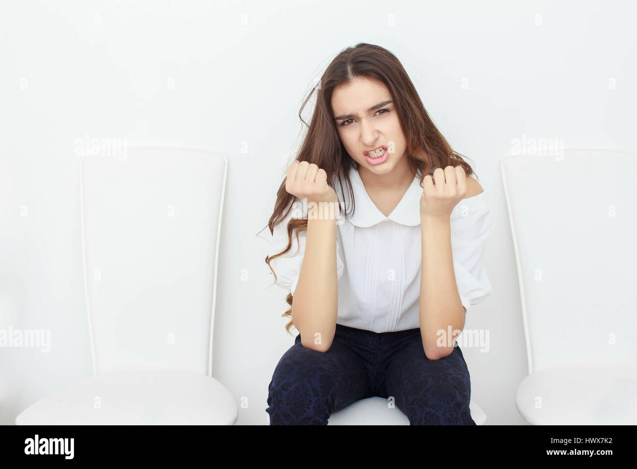 A beautiful girl is sitting on chair and angry Stock Photo - Alamy