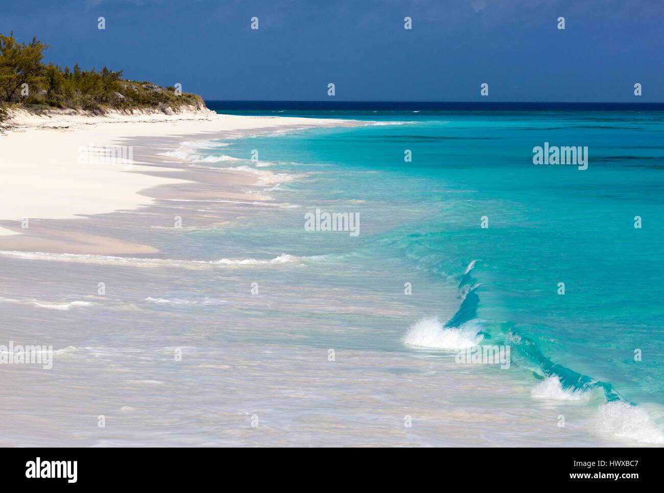 Small waves hitting endless beach on uninhabited island Half Moon Cay ...