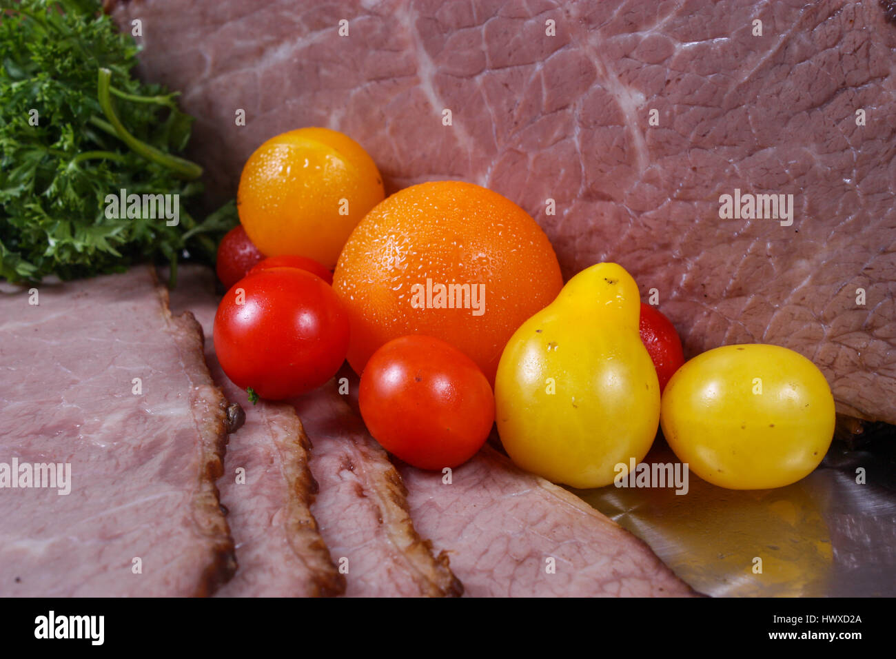 piece of sliced meat and small tomatoes Stock Photo - Alamy