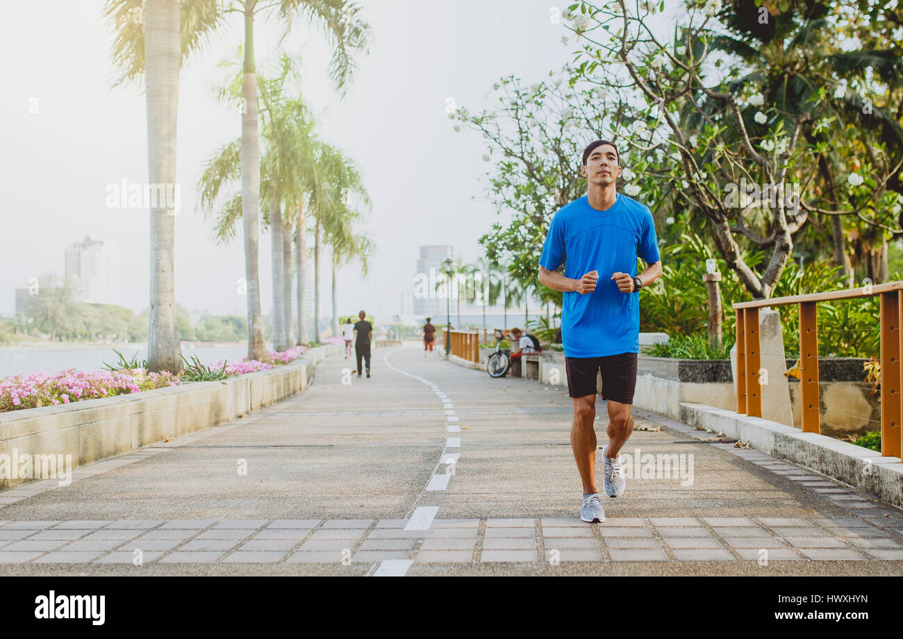 Running man. Male runner jogging during outdoor workout at public park ...