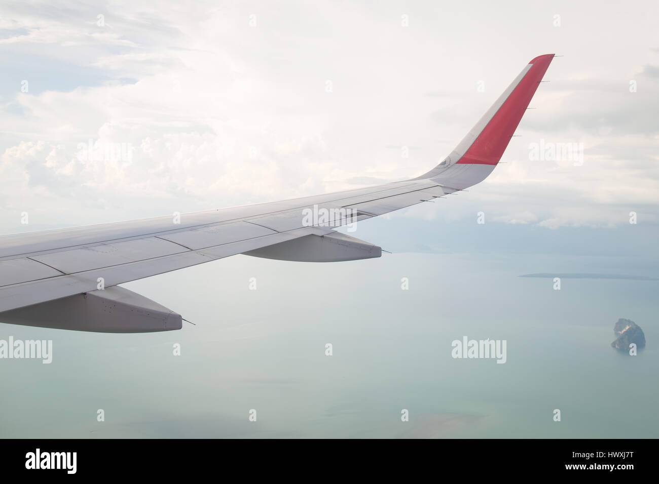 Wing of an airplane flying above the ocean and many island Stock Photo ...