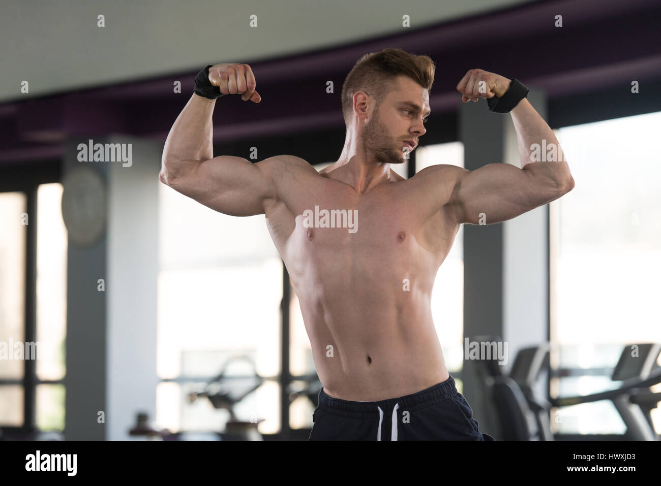 Healthy Man Standing Strong In The Gym And Flexing Muscles - Muscular ...