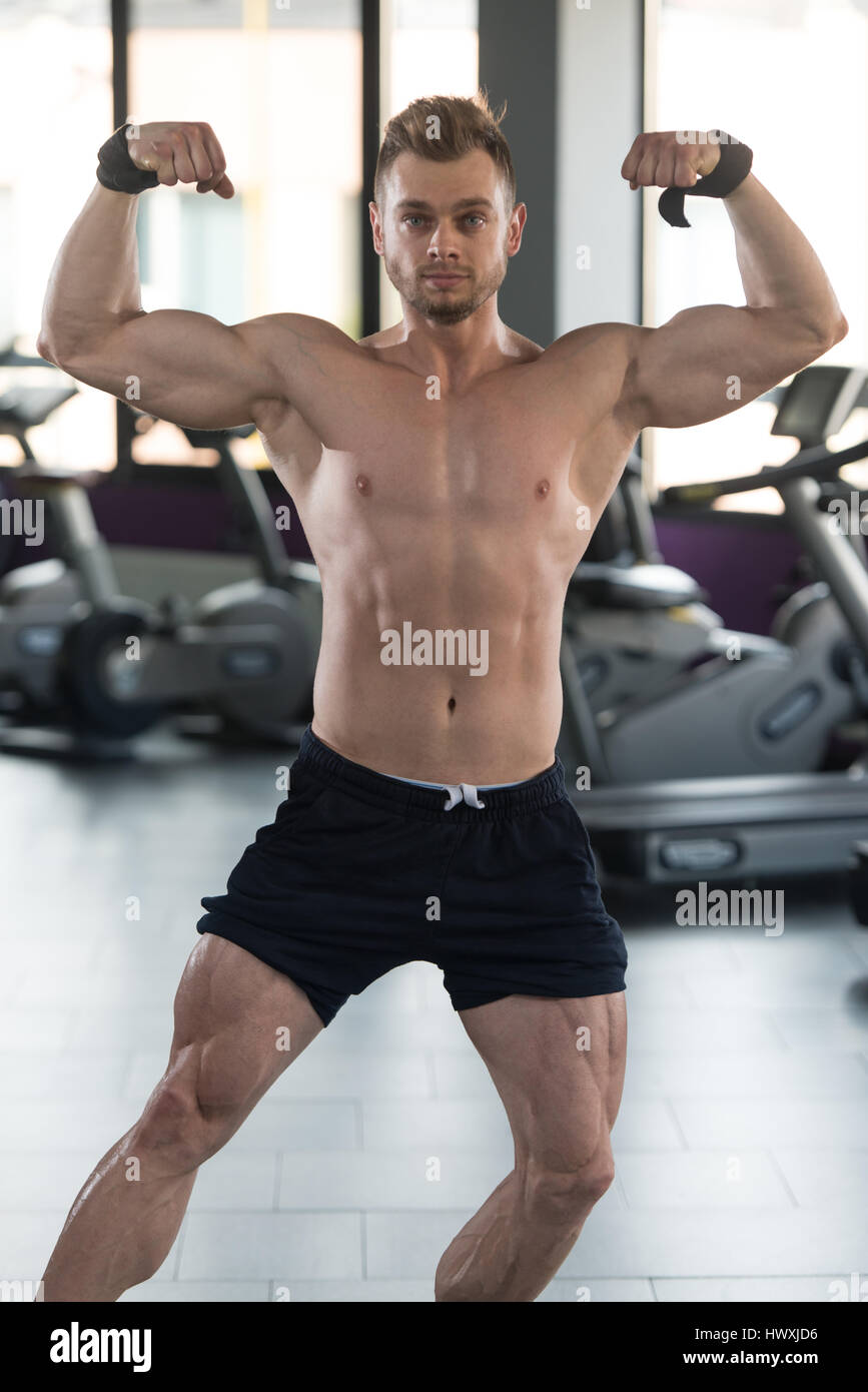 Healthy Man Standing Strong In The Gym And Flexing Muscles - Muscular ...