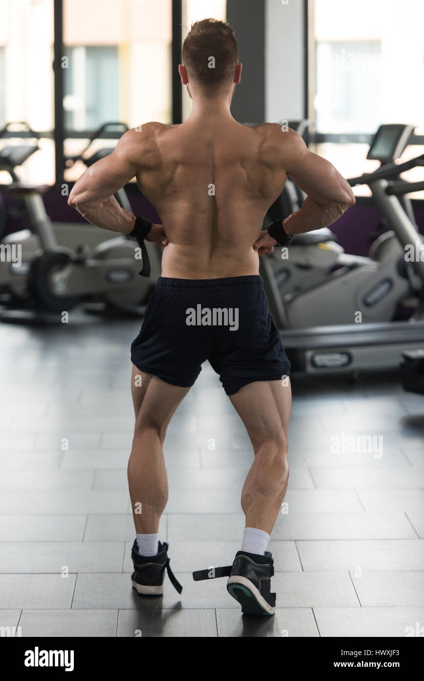 Handsome Man Standing Strong In A Modern Gym And Flexing Muscles ...