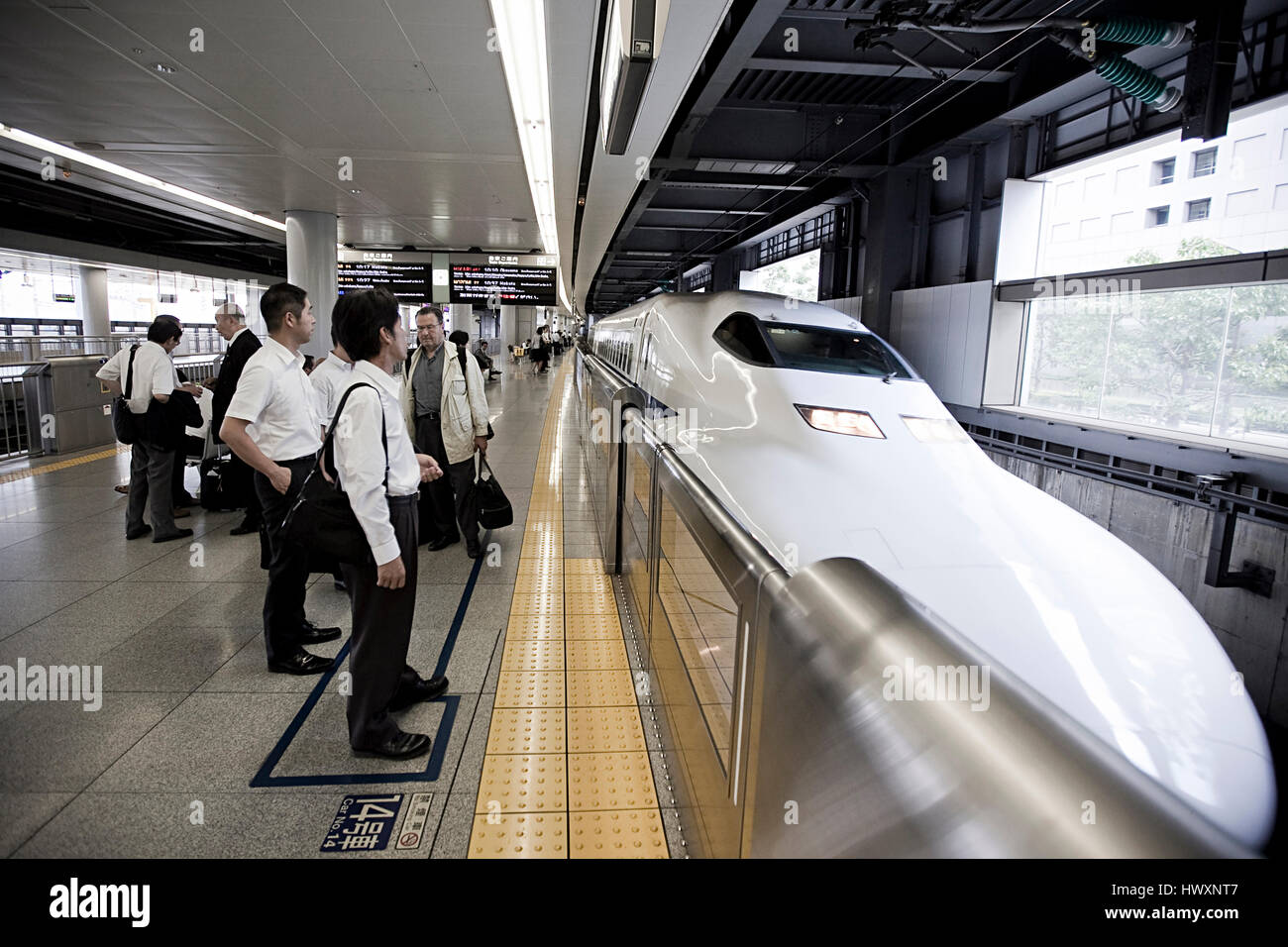 Passengers are waiting for the Shinkansen train to arrive. The Shinkansen is a high-speed train ...